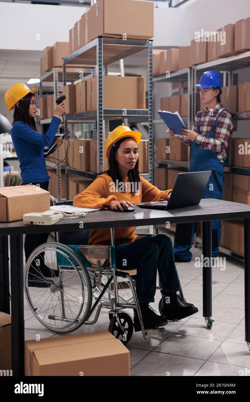 Order fulfillment warehouse worker in wheelchair doing goods stock ...