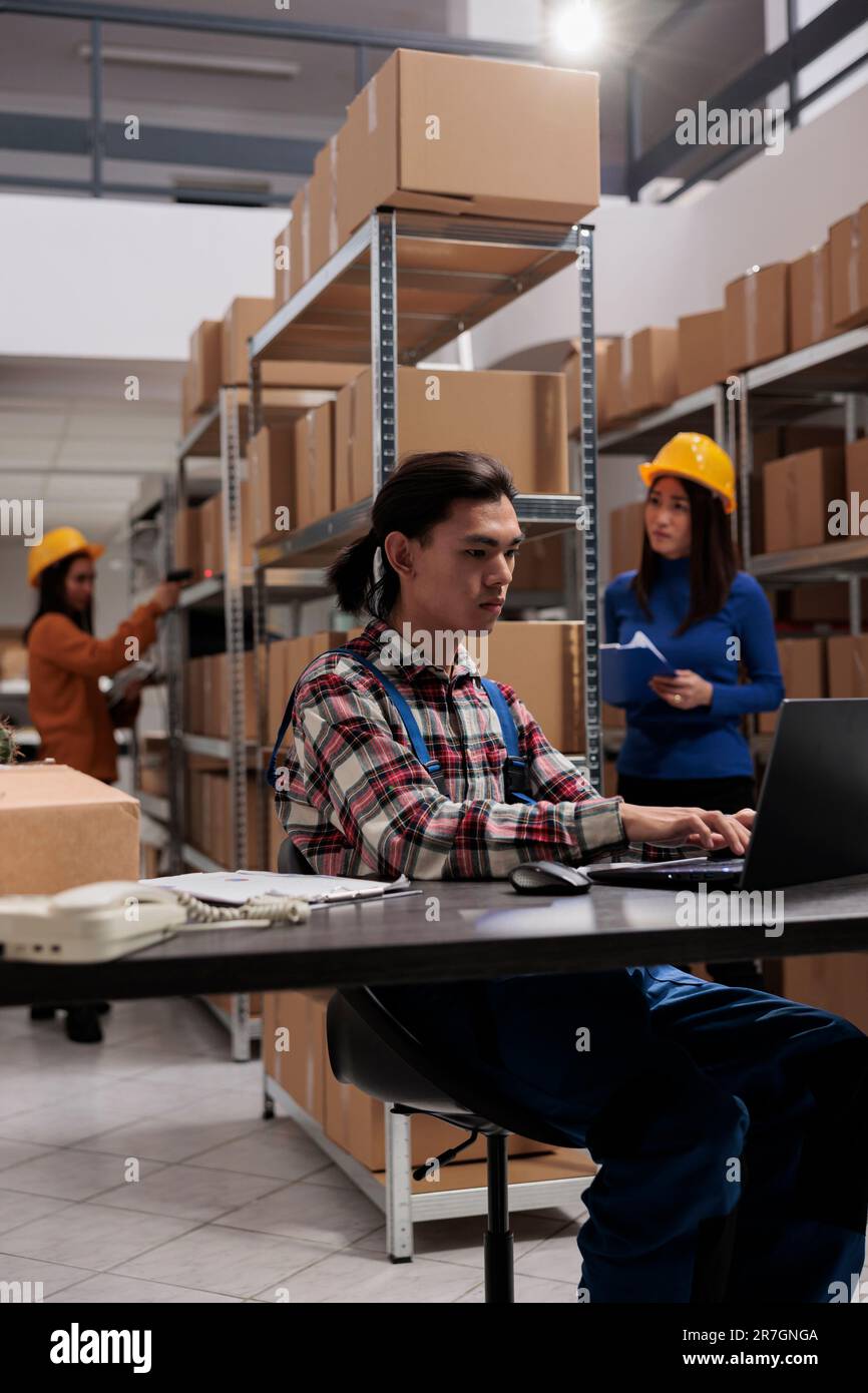 Logistics manager planning goods supply on laptop in freight warehouse ...