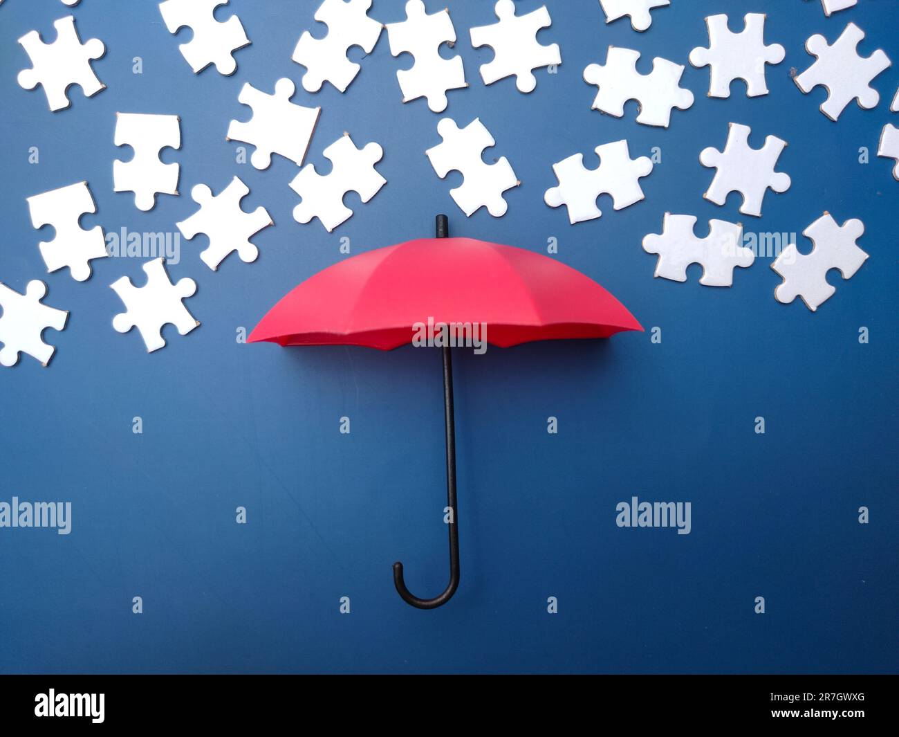 A still image of a red umbrella puzzle piece formation against a bright blue background Stock ...