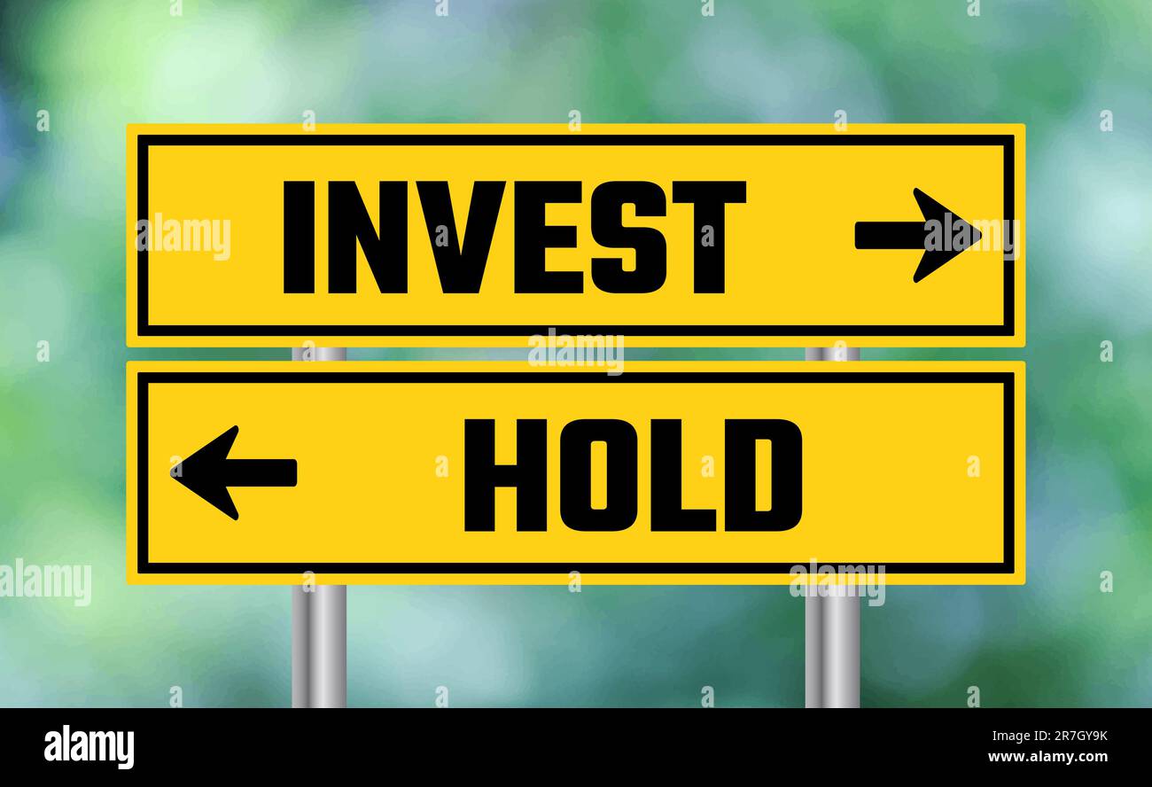 Invest or hold road sign on blur background Stock Photo - Alamy