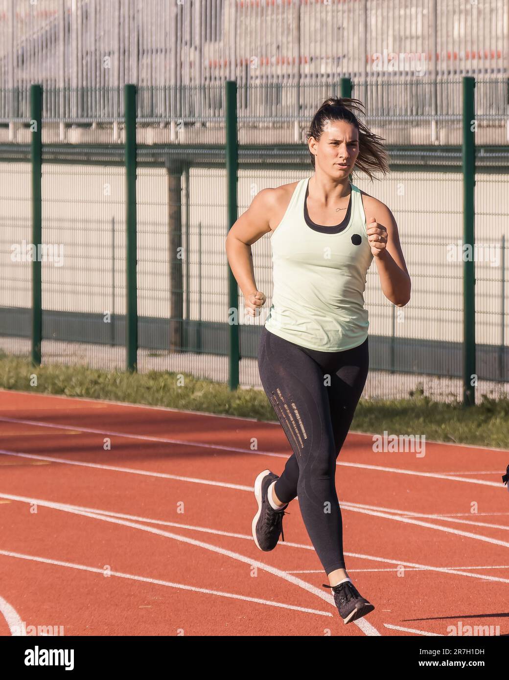 Young, strong, determined Caucasian female athlete in the sprint ...