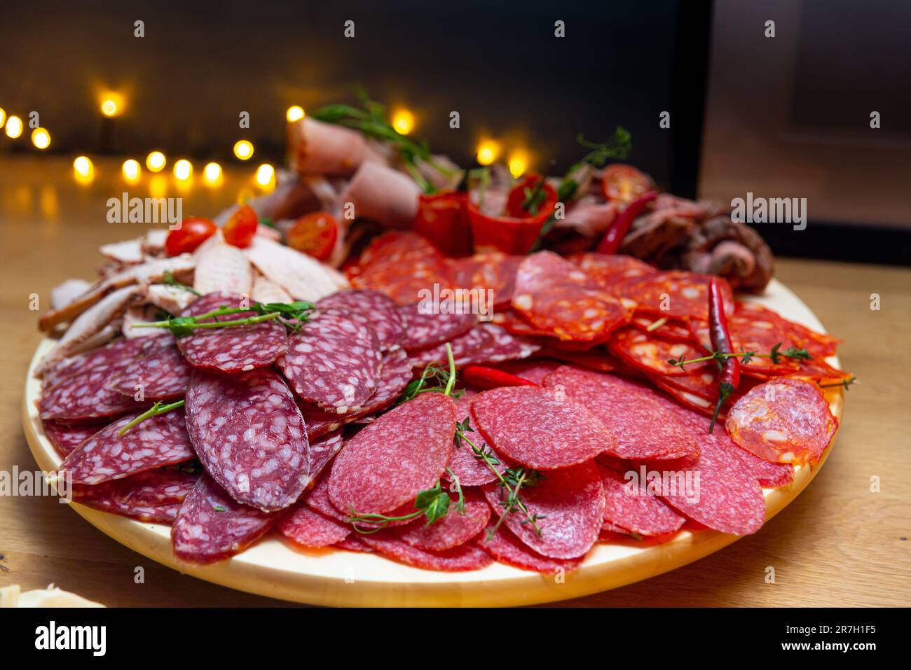 Slices of salami on a wooden board. Assorted charcuterie platter with ...