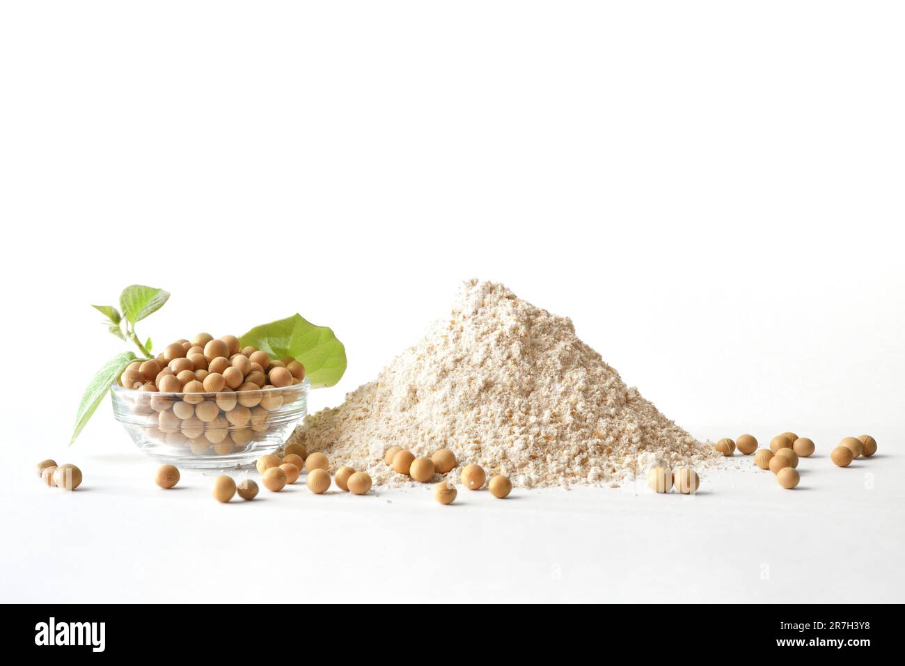 Heap of whole soy flour with soybeans in a glass bowl with leaves and ...