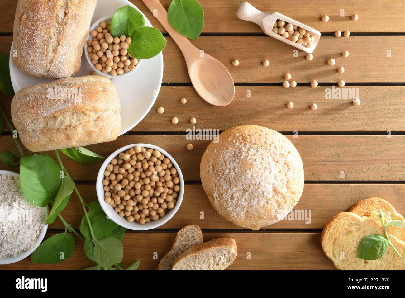 Soybean bread and seeds in bowls on wooden table with leaves and flour ...