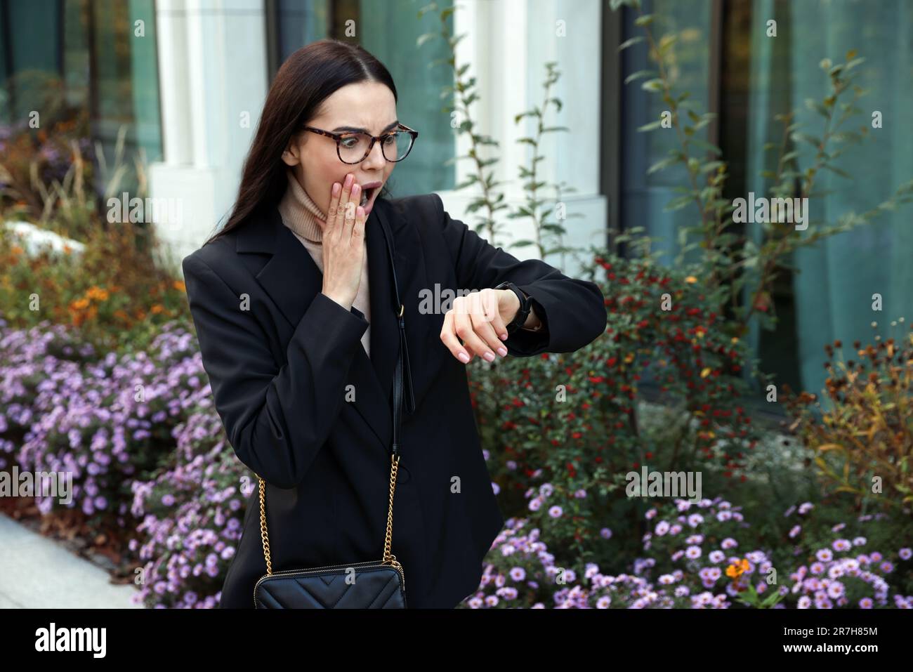 Emotional woman checking time on watch outdoors. Being late concept ...