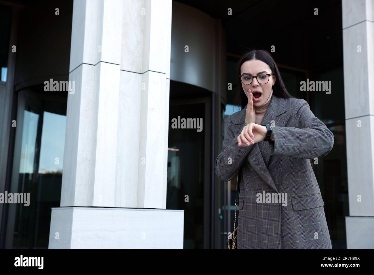 Emotional woman checking time on watch outdoors. Being late concept ...