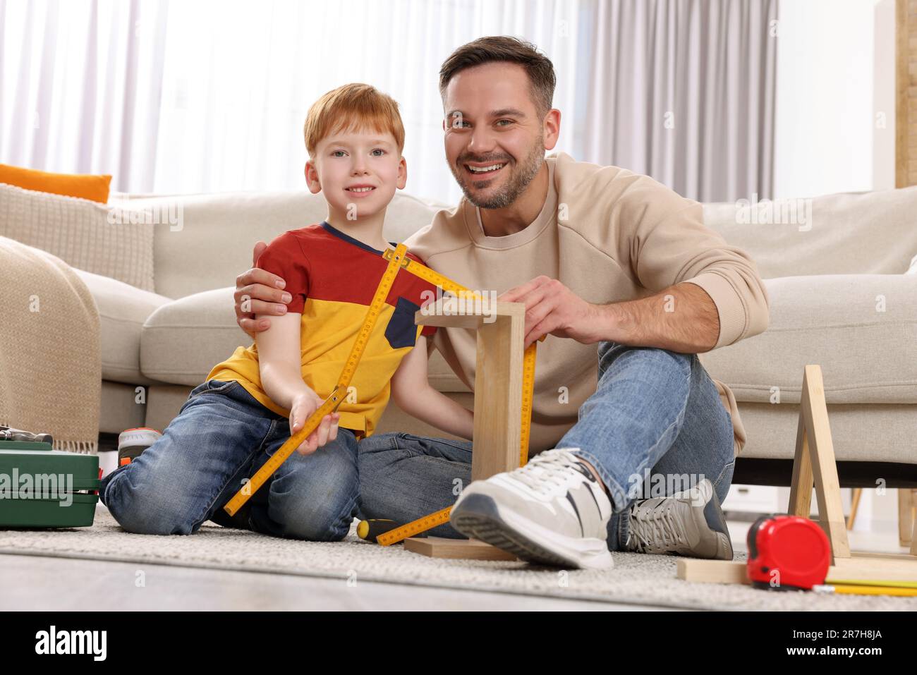 Father and son measuring shelf together at home. Repair work Stock ...
