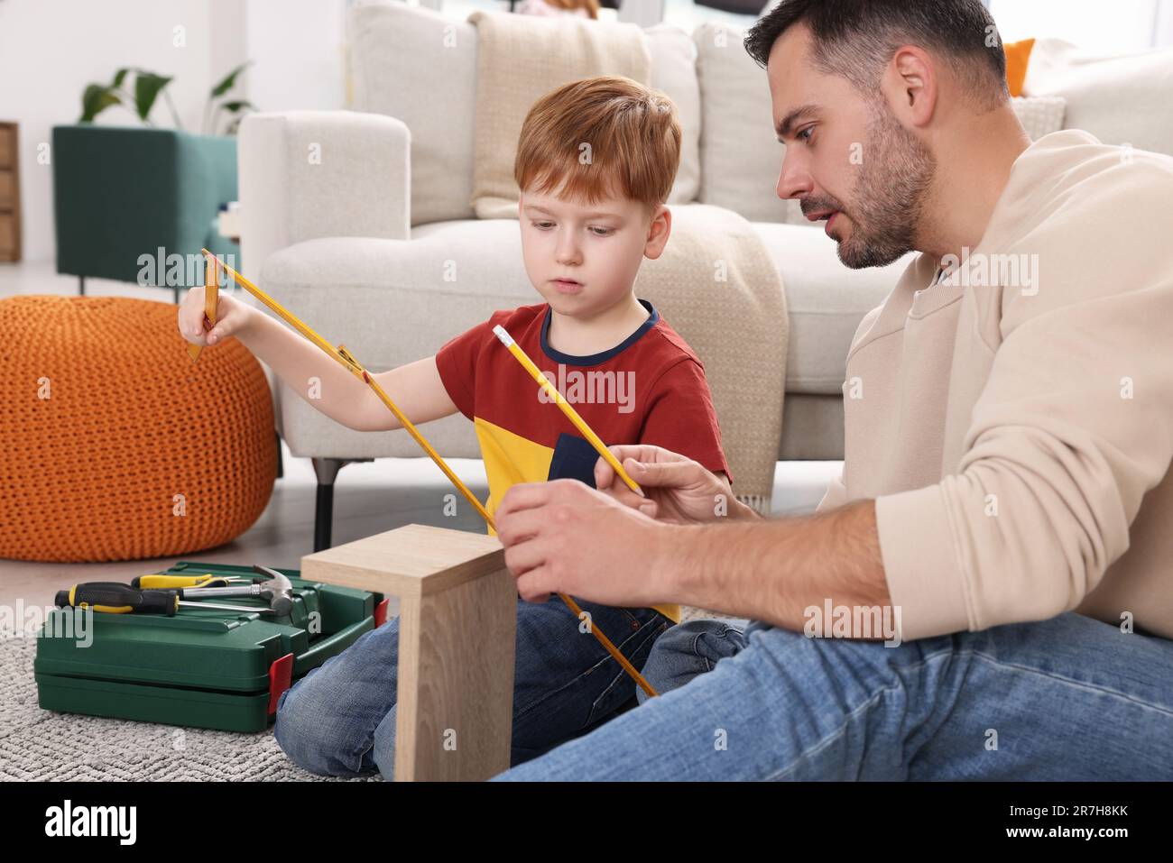 Father and son measuring shelf together at home. Repair work Stock ...