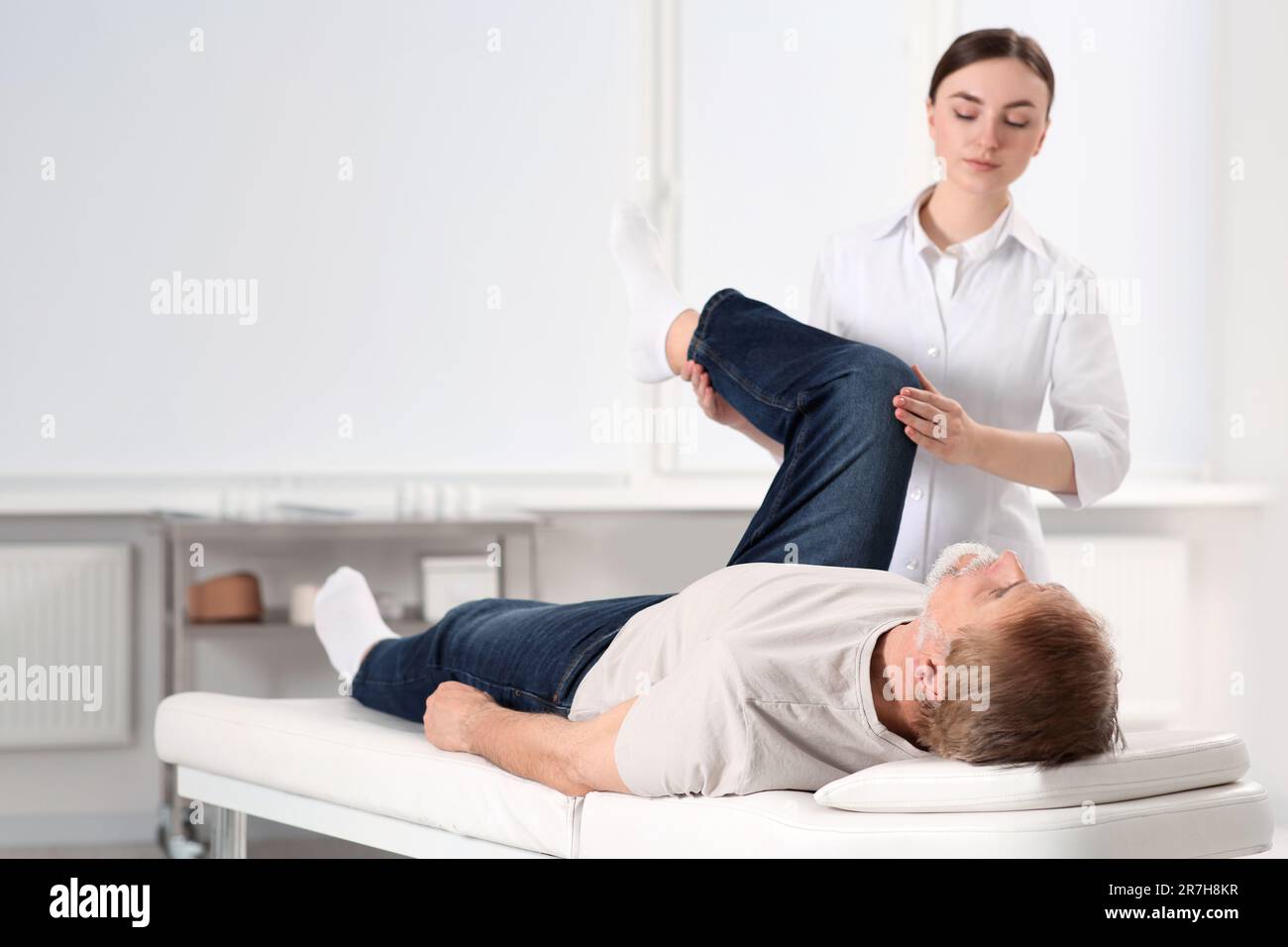 Professional orthopedist examining patient's leg in clinic Stock Photo ...