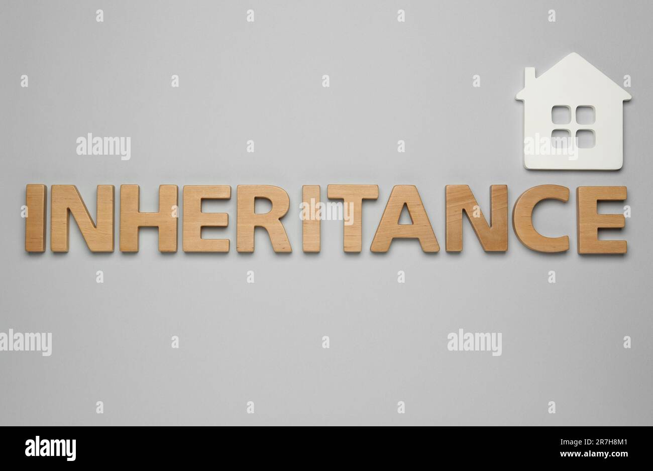 Word Inheritance made with wooden letters and house model on light ...