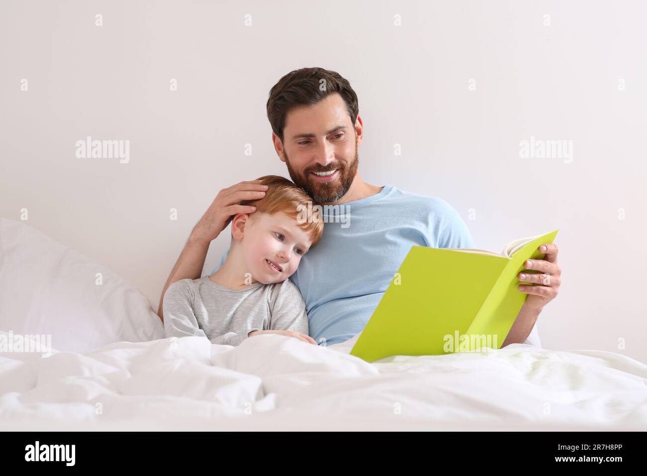 Father reading book with his child on bed at home Stock Photo - Alamy