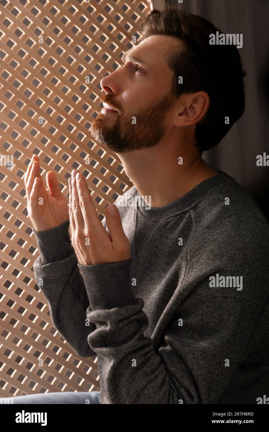 Man praying to God during confession in booth Stock Photo - Alamy