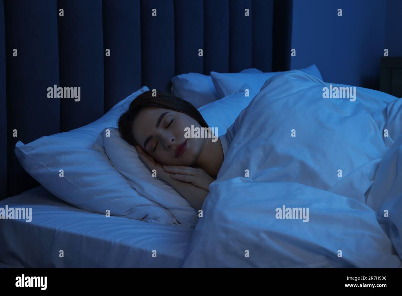 Beautiful young woman sleeping in bed at night Stock Photo - Alamy