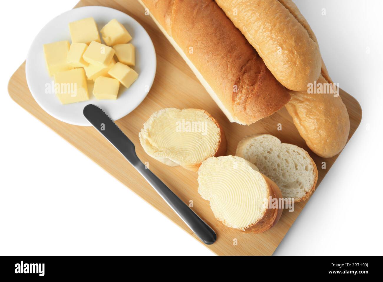 Whole and cut baguettes with fresh butter on white background, top view ...