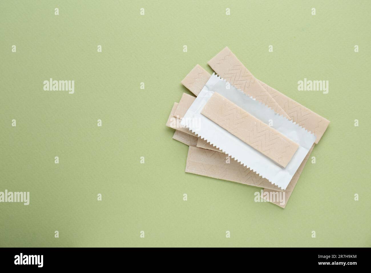 Many sticks of tasty chewing gum on light green background, flat lay ...