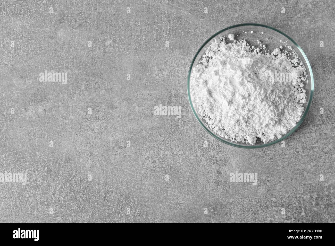 Petri dish with calcium carbonate powder on light grey table, top view ...