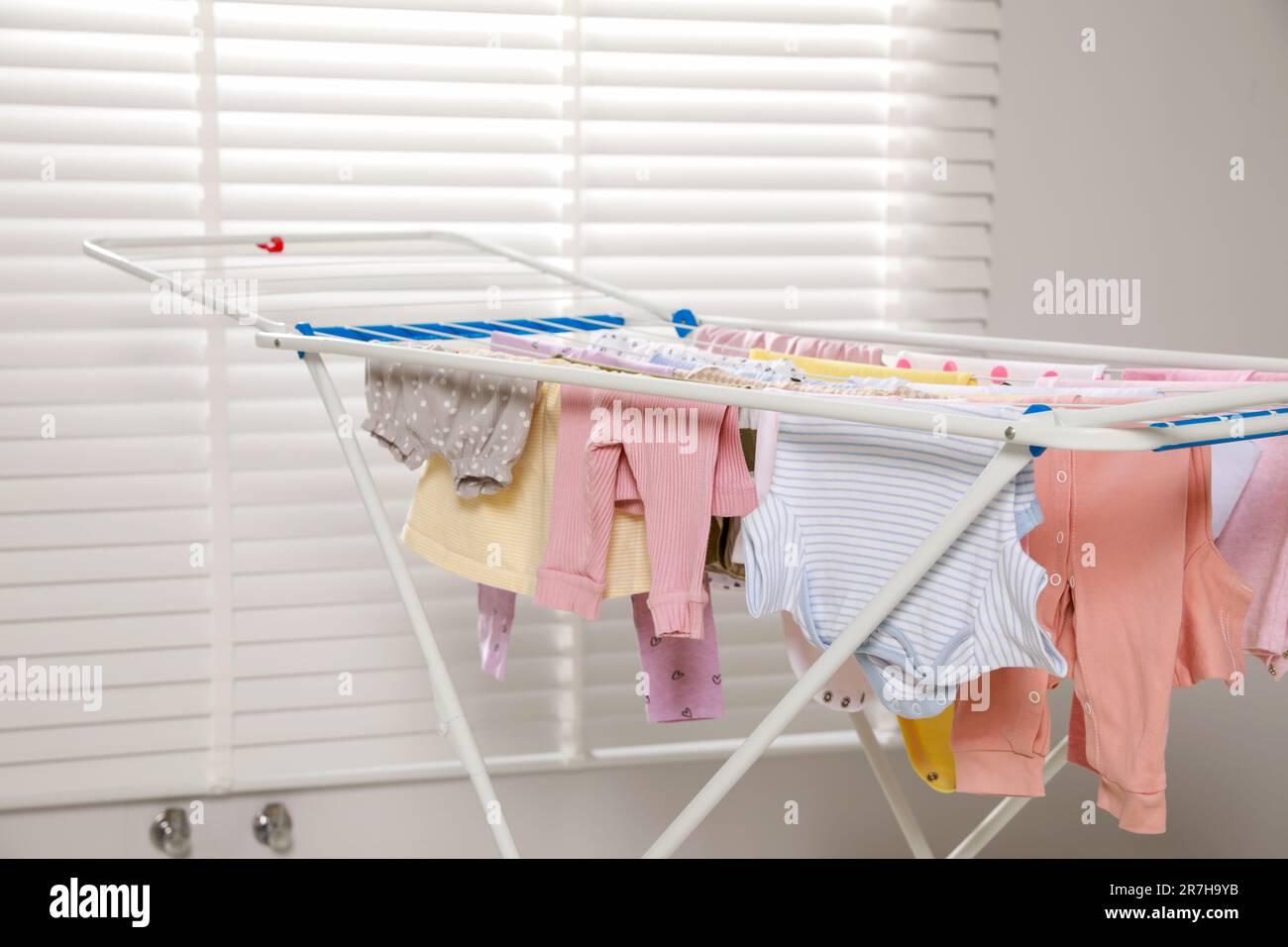 Clean laundry hanging on drying rack indoors Stock Photo - Alamy