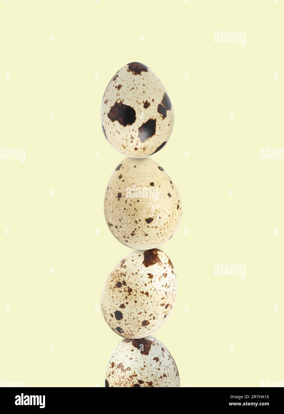 Stacked speckled quail eggs on light beige background Stock Photo - Alamy