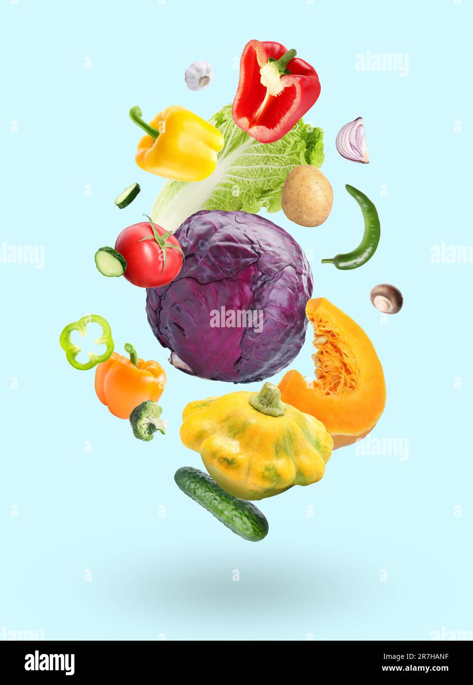Many different fresh vegetables falling on pale light blue background ...