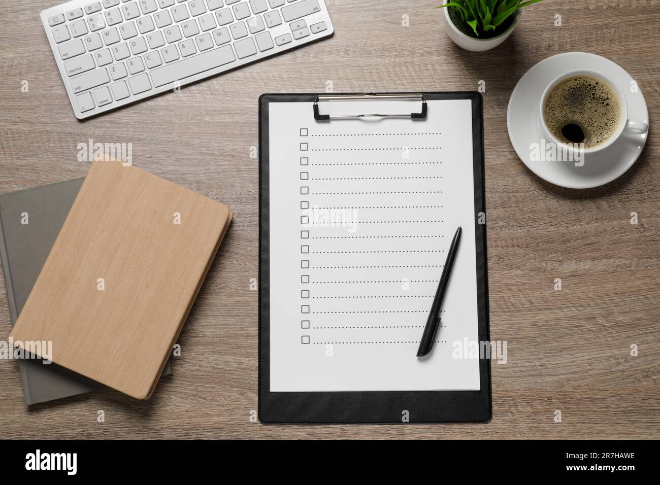 Clipboard with checkboxes, cup of coffee, plant and computer keyboard ...