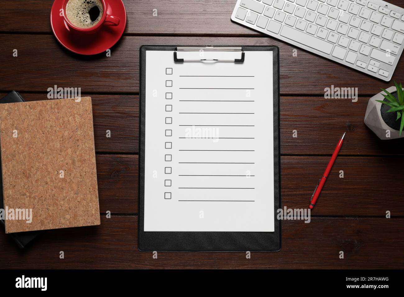 Clipboard with checkboxes, cup of coffee, plant and computer keyboard ...