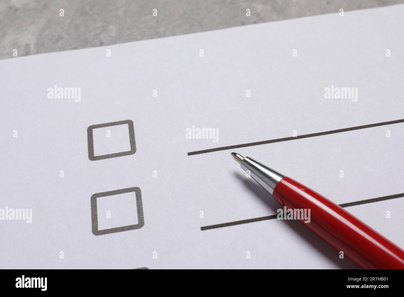 Paper sheet with checkboxes and pen on light grey table, closeup ...