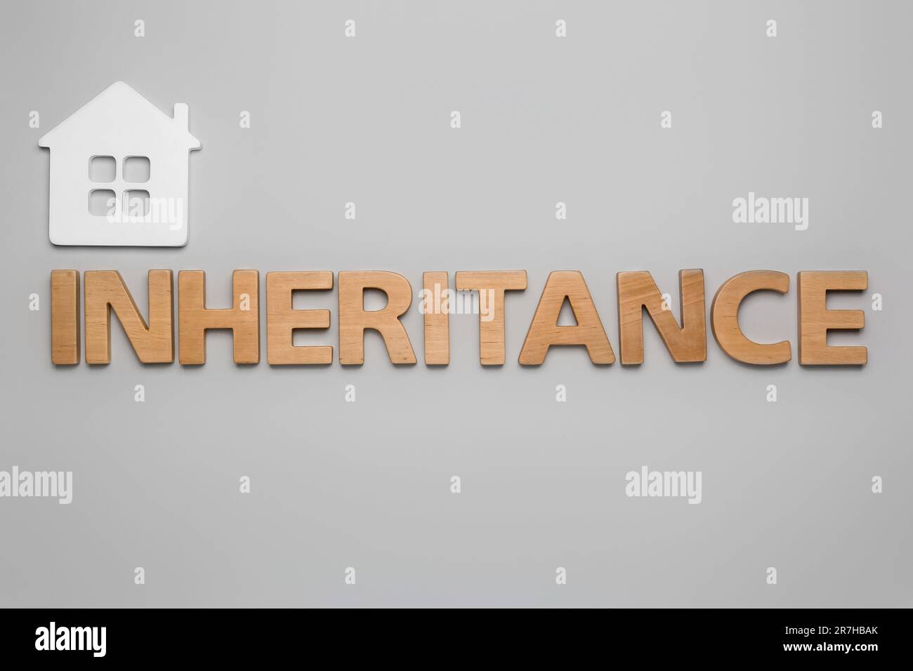 Word Inheritance made with wooden letters and house model on light ...