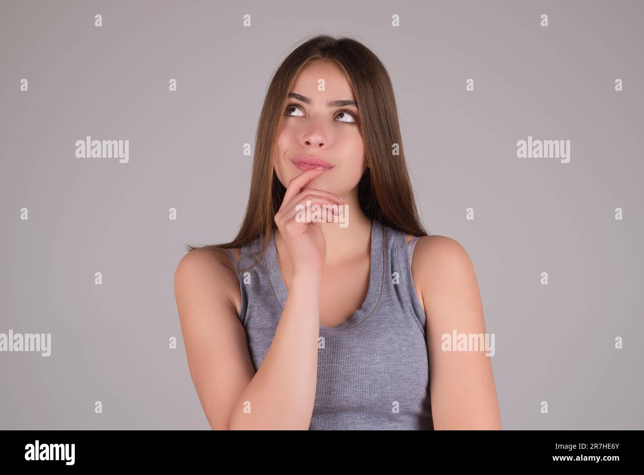 Thinking concept. Portrait of focused smart and creative woman, holding ...