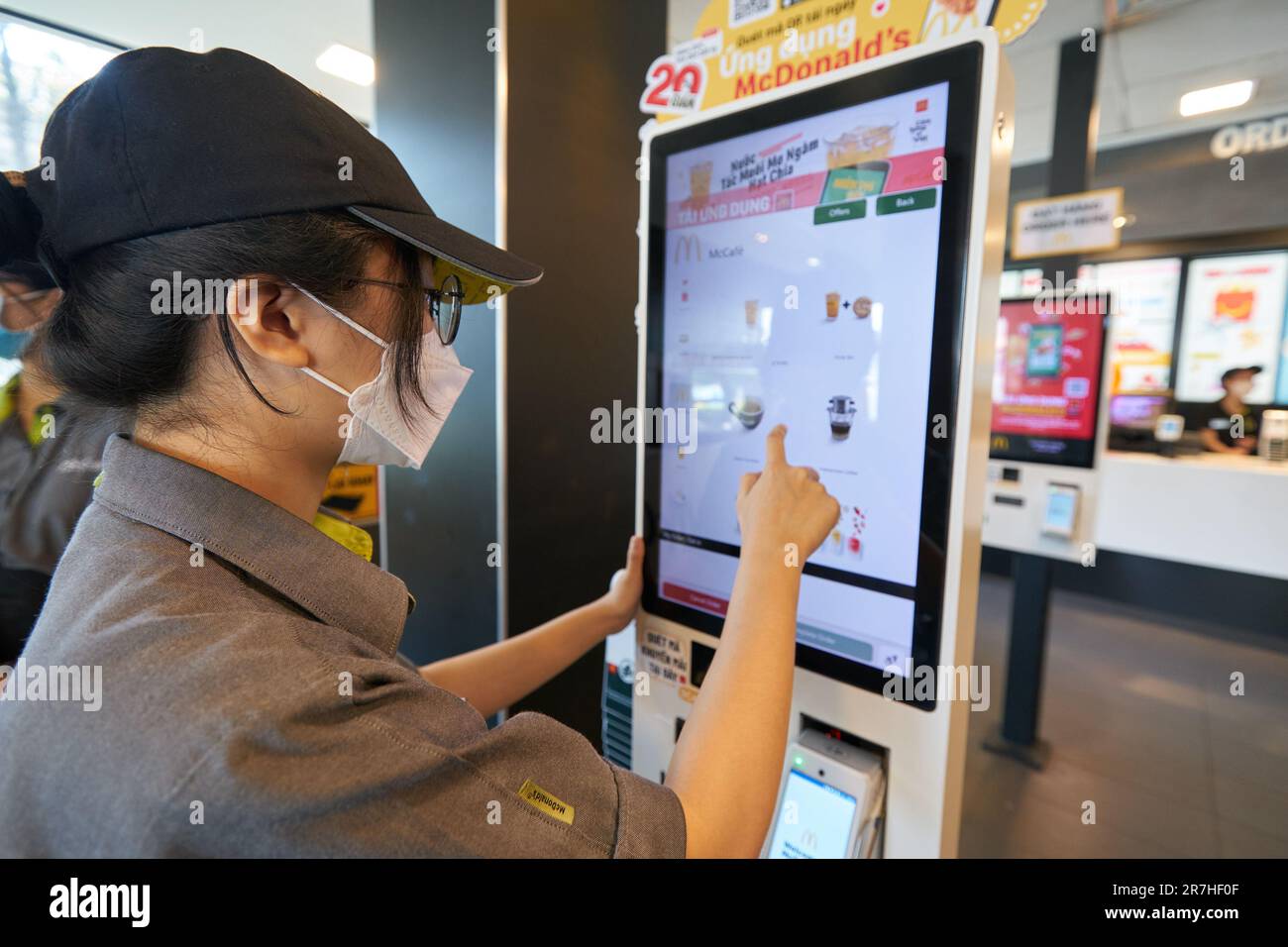 HO CHI MINH CITY, VIETNAM - CIRCA MARCH, 2023: employee use self-ordering kiosk at McDonald's ...