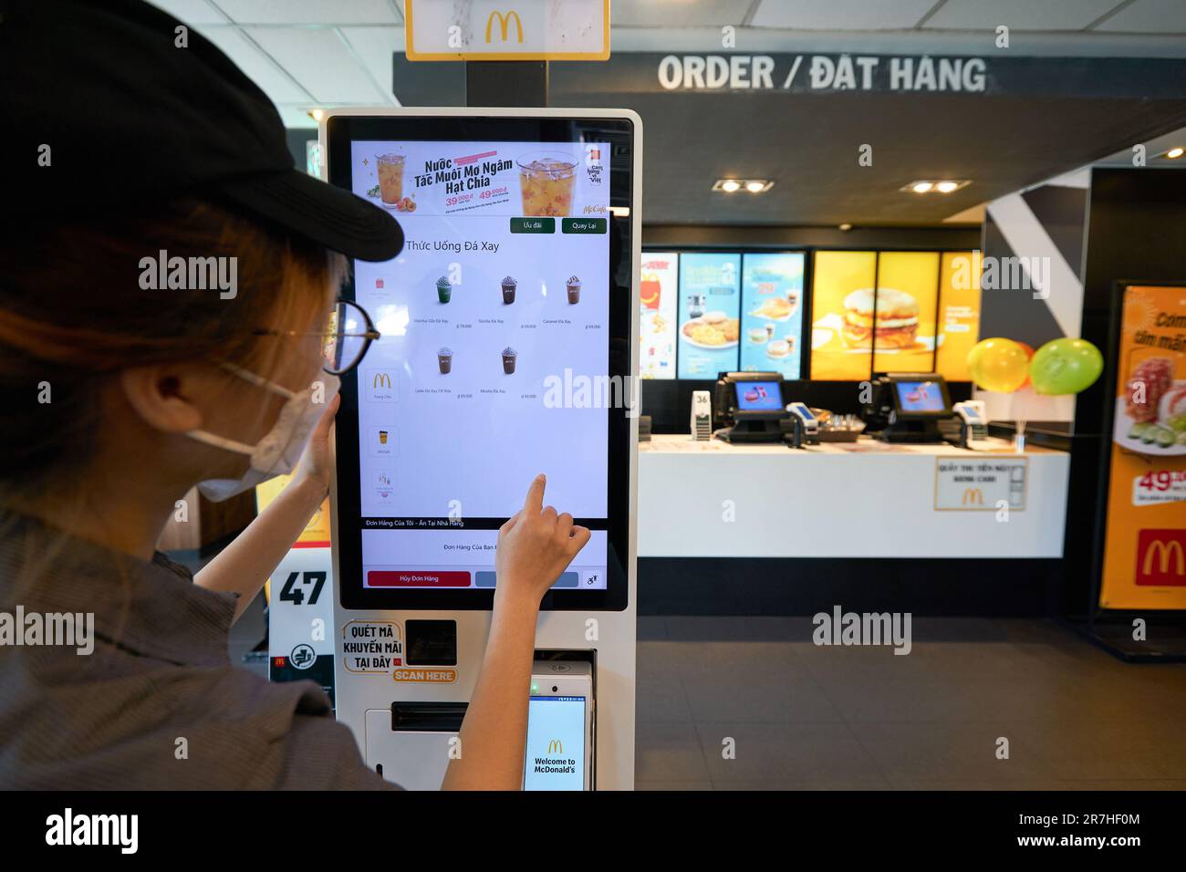 HO CHI MINH CITY, VIETNAM - CIRCA MARCH, 2023: employee use self-ordering kiosk at McDonald's ...