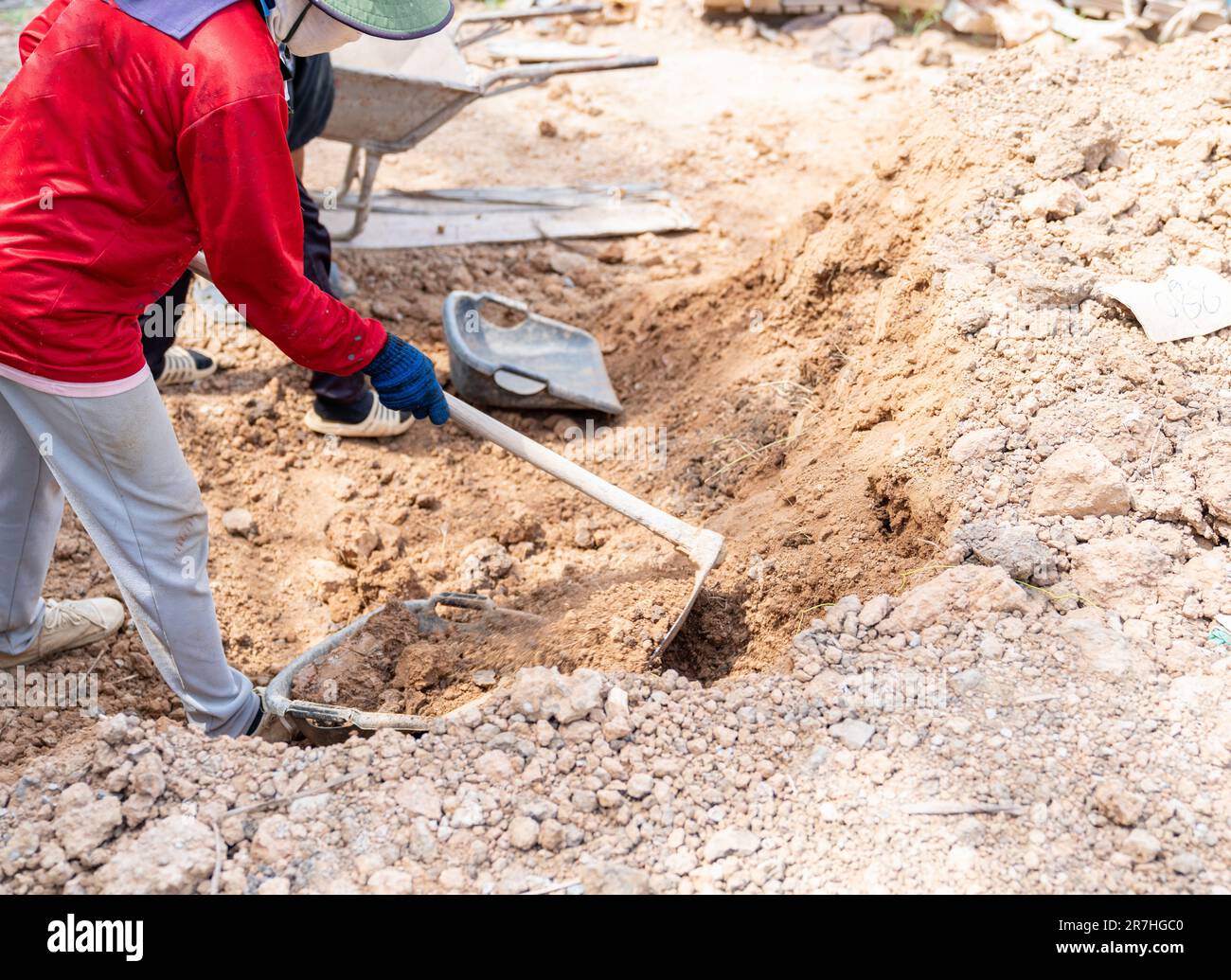 Worker dig soil to basket for transport in building site Stock Photo ...