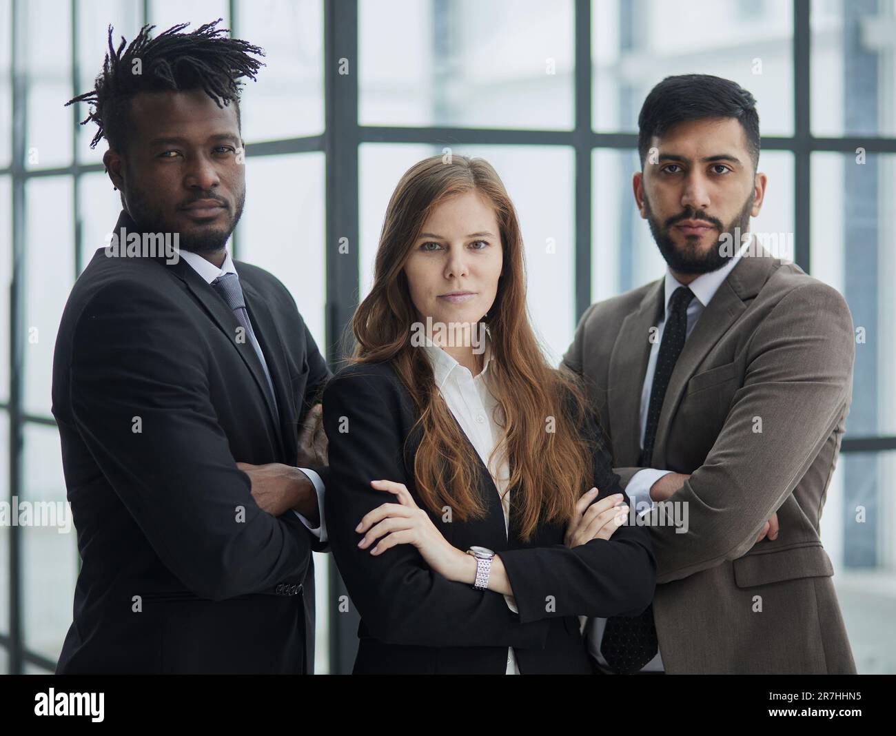 a group of three employees posing together with their arms crossed ...