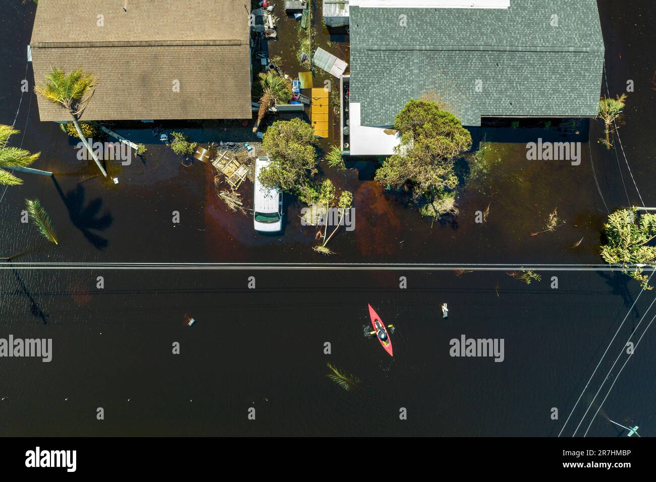 Consequences of natural disaster. Kayak boat floating on flooded street ...