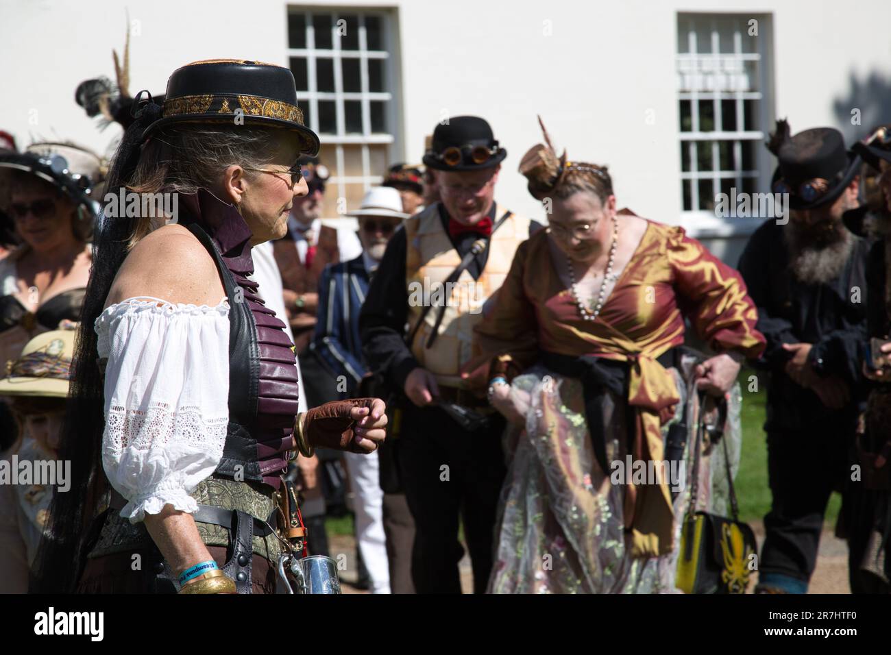 A group of people wearing colorful costumes stand outside a large ...