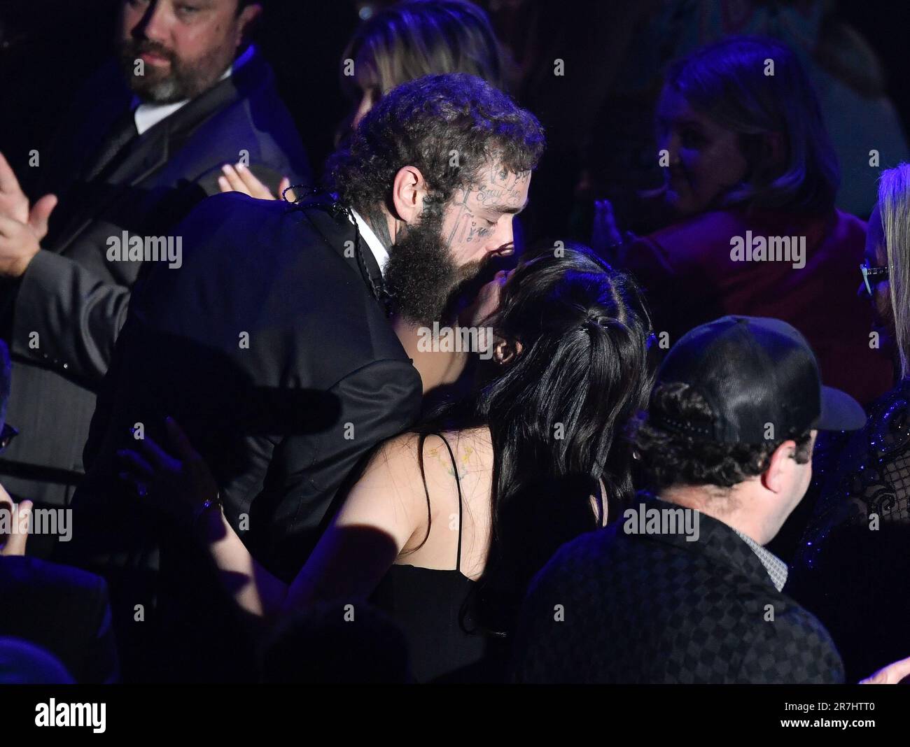 Hoinoree Post Malone, left, kisses his fiancé Jamie at the 52nd annual ...