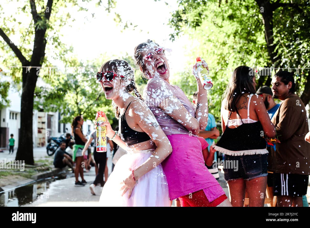 Two female friends laughing, covered with foam on the street Stock ...