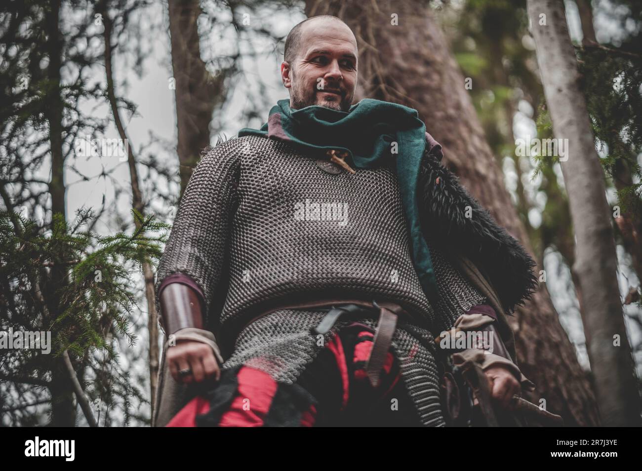 A man dressed in authentic medieval armor standing in the middle of ...