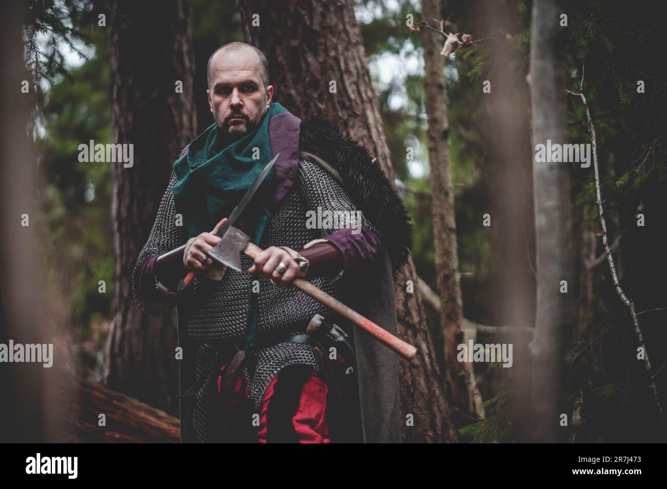 A man dressed in authentic medieval armor standing in the middle of ...