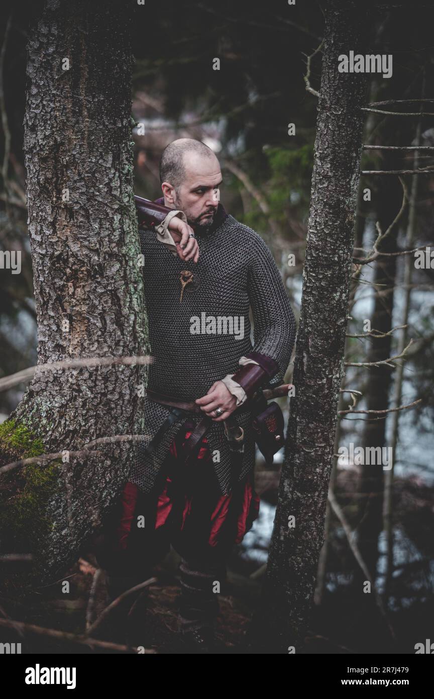 A man dressed in authentic medieval armor standing in the middle of ...