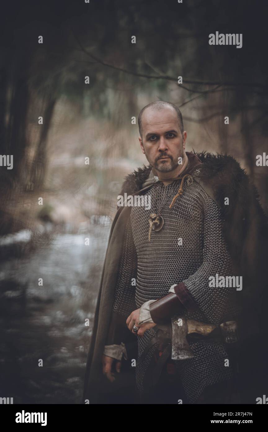 A man dressed in authentic medieval armor standing in the middle of ...