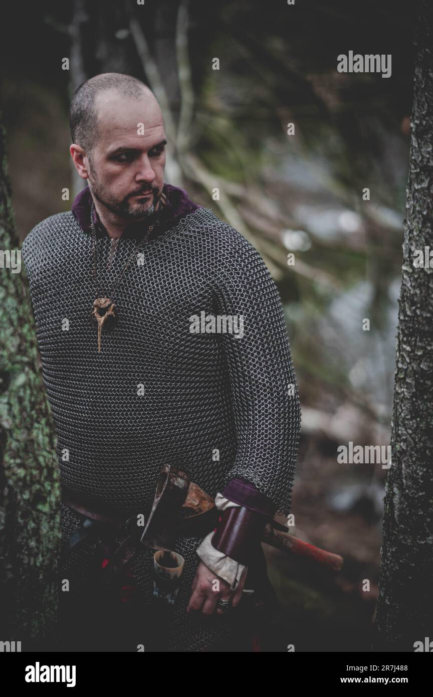 A man dressed in authentic medieval armor standing in the middle of ...