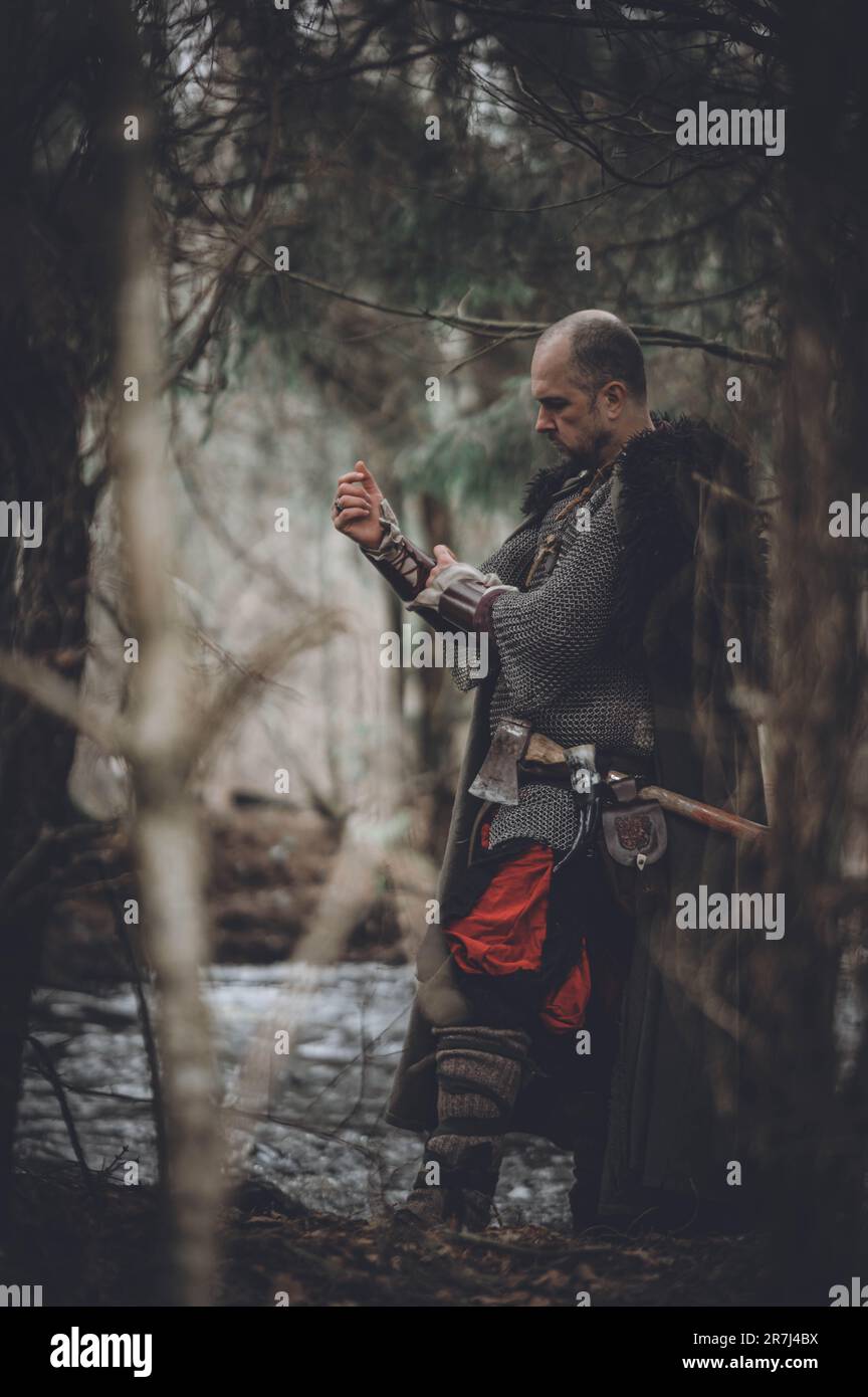 A man dressed in authentic medieval armor standing in the middle of ...