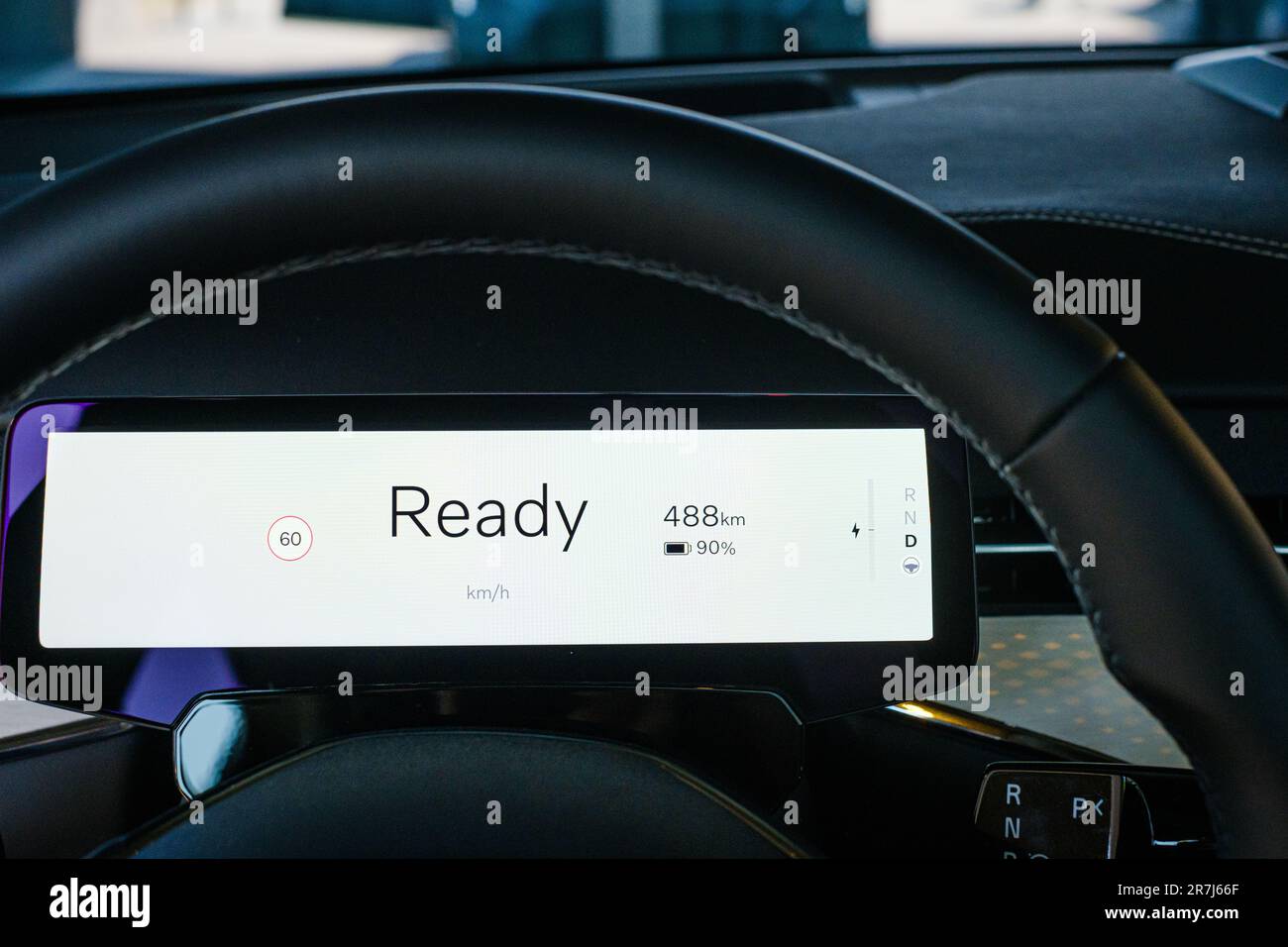 A close-up of a modern smart car's dashboard display with the word ...