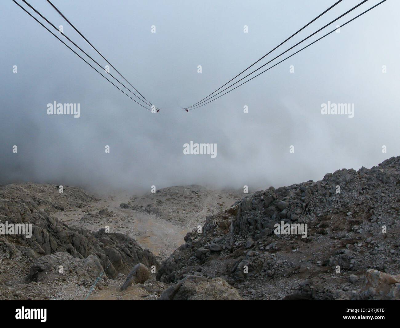 funicular's cables going down from the top of the mountain into thick ...