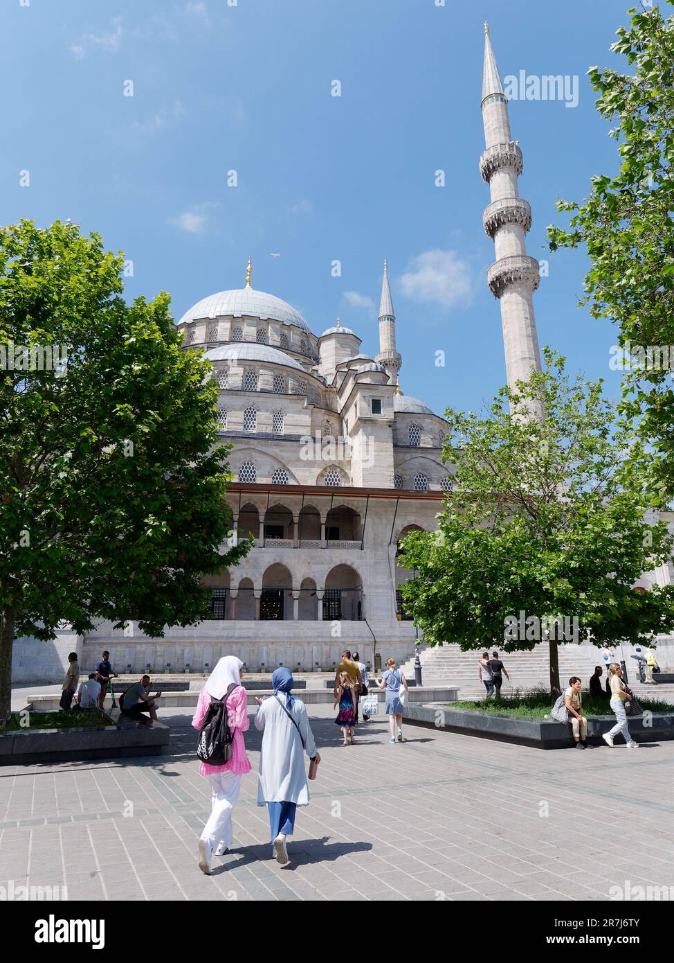 People in traditional Muslim attire walk past the Yeni Cami mosque in ...