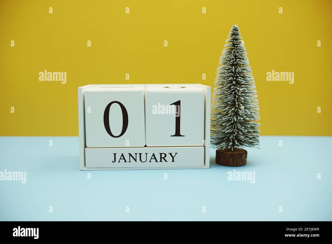 Wooden calendar 1st January with chirtsmas tree on yellow and blue ...