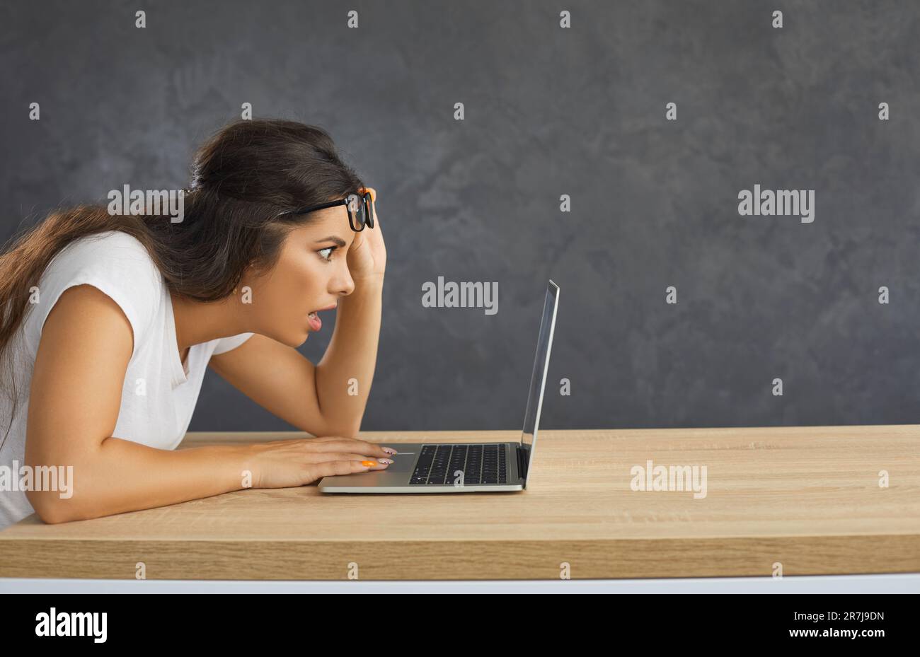 Shocked young woman who can't believe what she sees staring at the ...