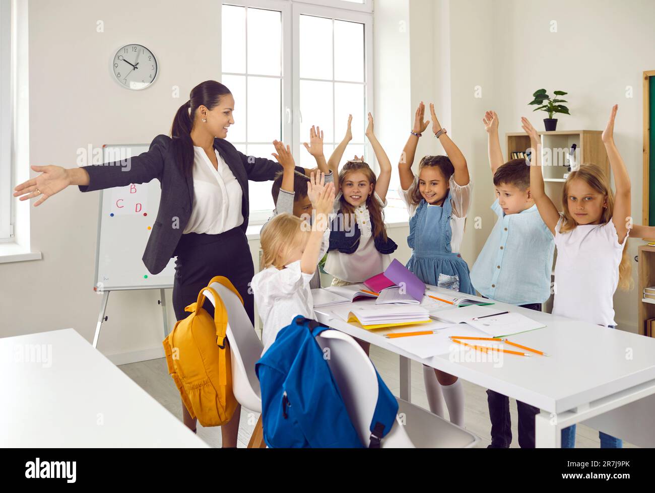 Happy children and their female teacher having fun together during ...