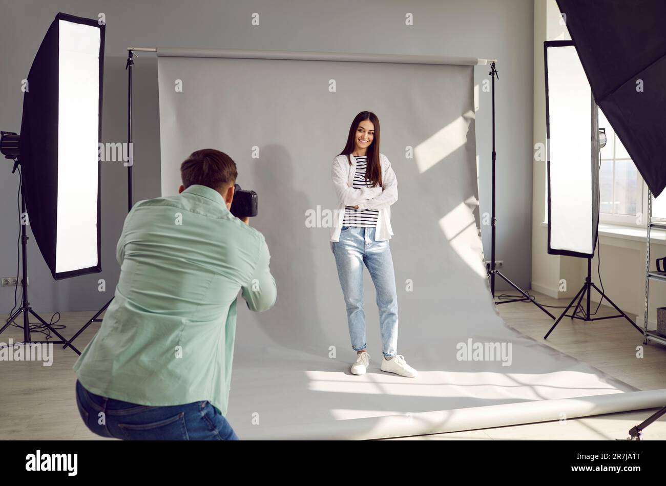 Male photographer shooting model in studio with softboxes Stock Photo ...