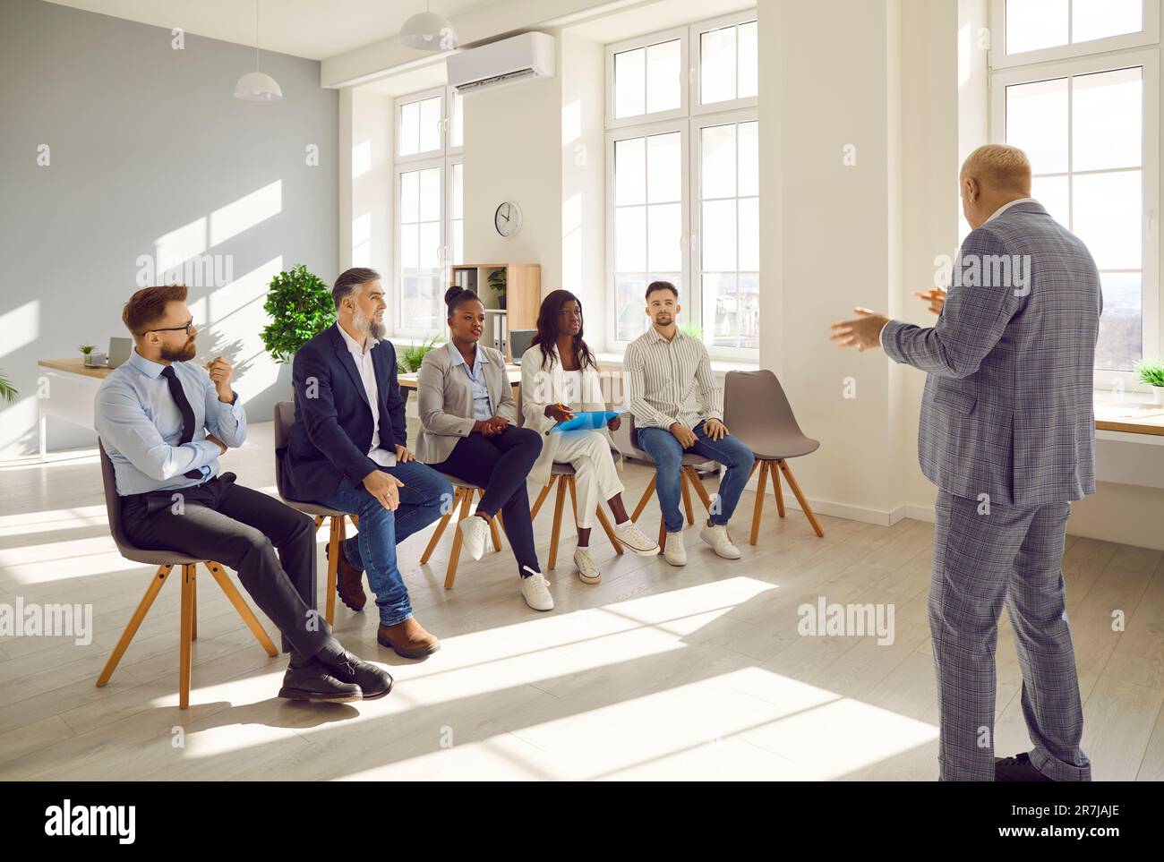 Business man speaking on a meeting in the office in front of a small ...